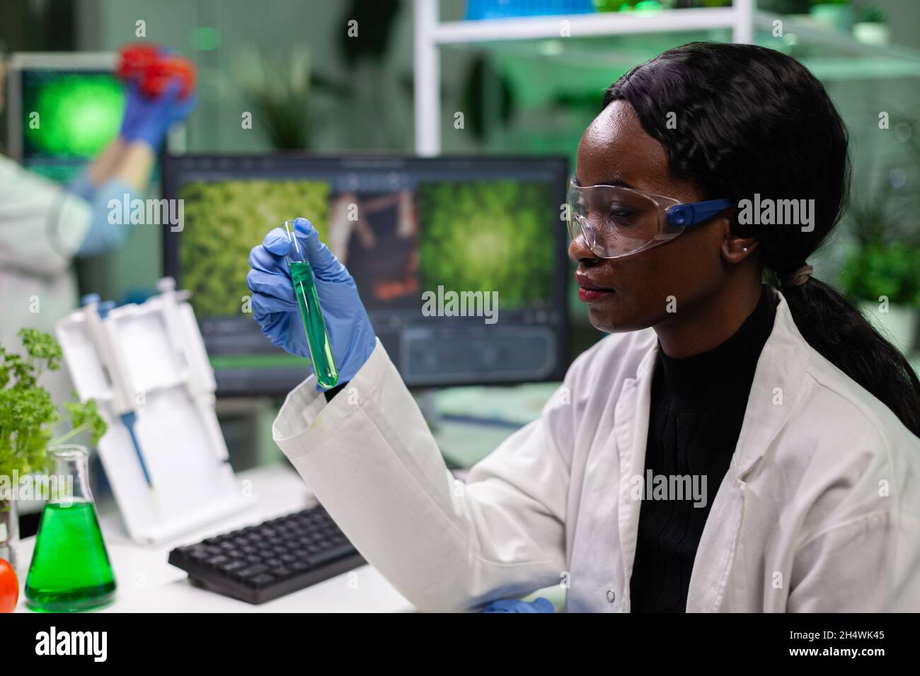 African american biologist researcher holding medical test tube with ...
