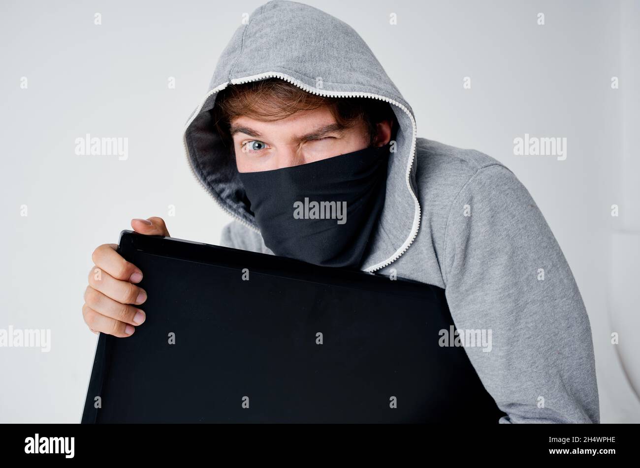 masked man hooded head hacking technology security light background Stock Photo - Alamy