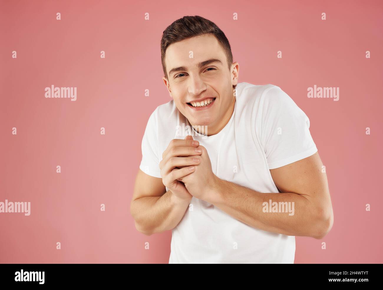 emotional man in white t-shirt gesturing with his hands moda studio pink background Stock Photo ...