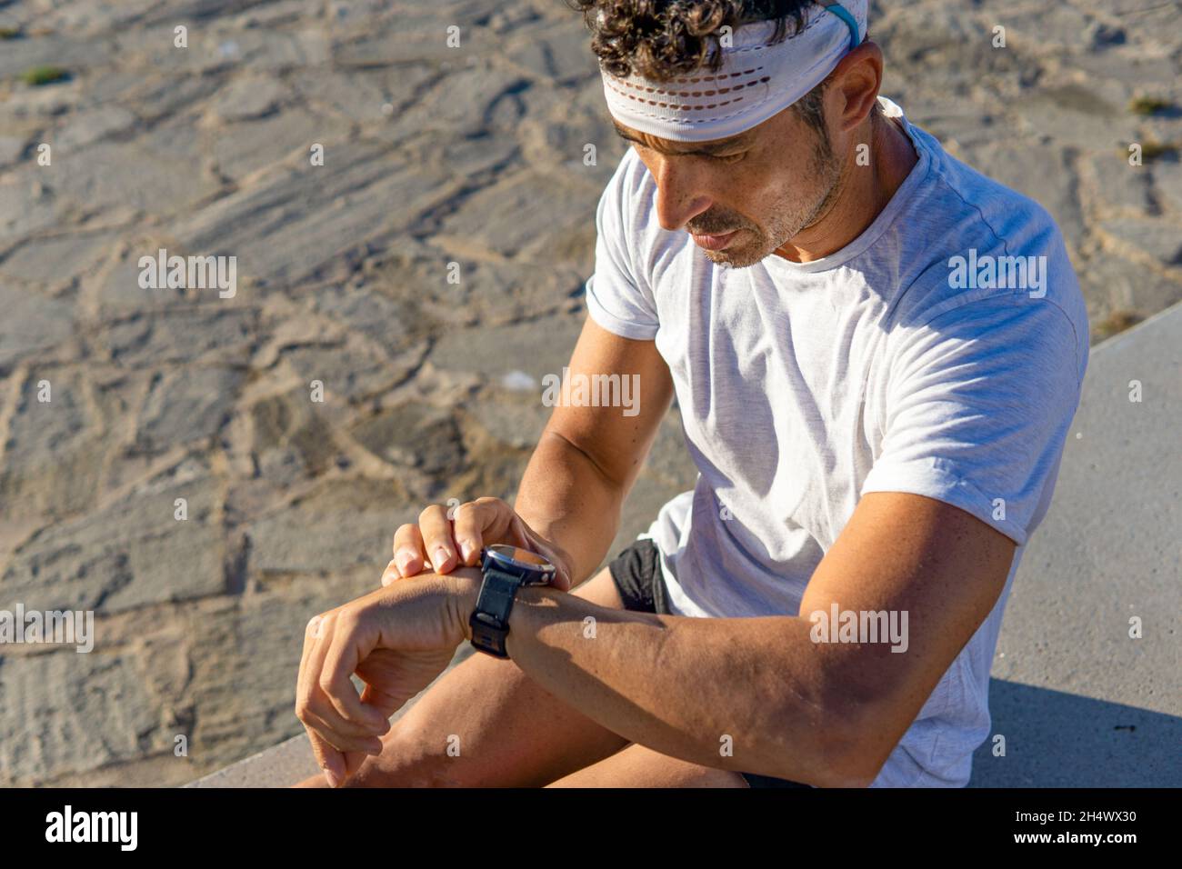 Young caucasian man checking pulse on a smartwatch in an outdoor Stock ...