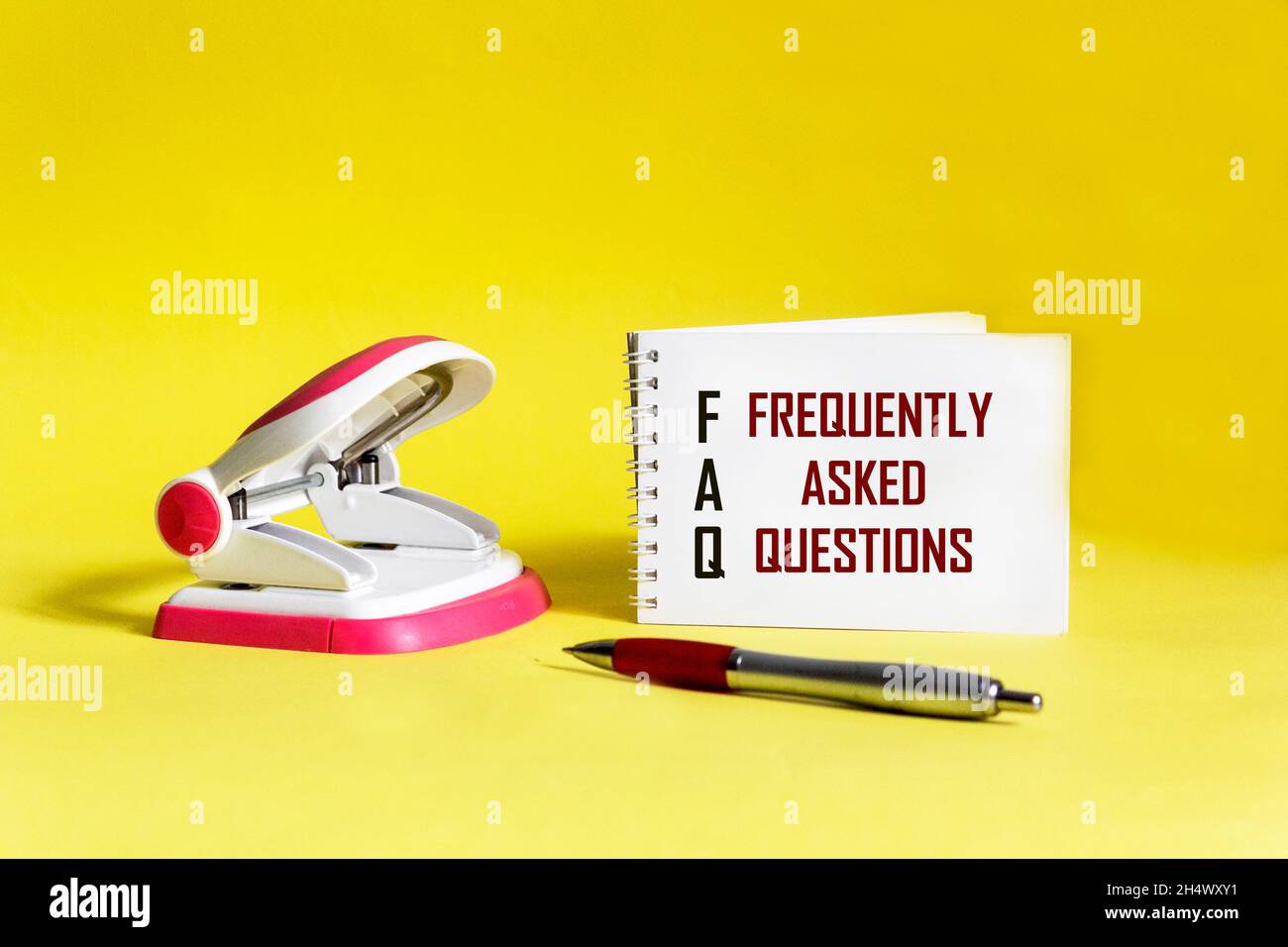 FAQ text, frequently asked questions, on a notepad, on a yellow ...