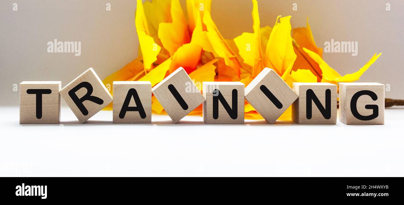 Training, word written on wooden cube and light background with orange ...