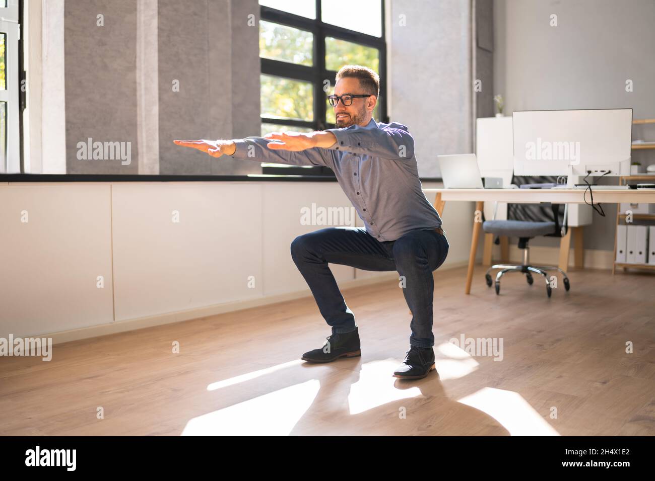 Workplace Exercise At Office Desk. Fit Man Doing Sit Up Stock Photo - Alamy