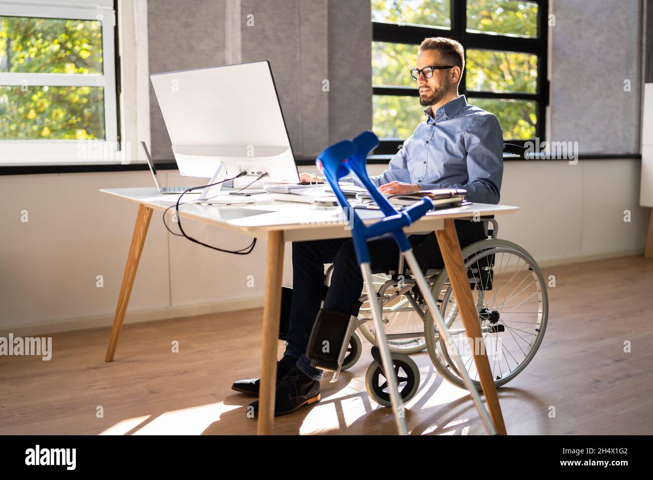 Businessman With Disabilities At Work Using Computer Stock Photo - Alamy