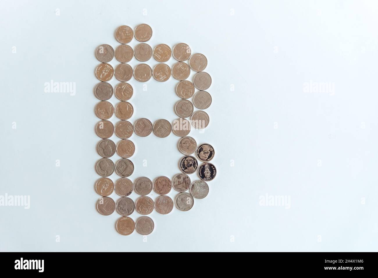 An alignment of Thai baht coins into Thai baht symbol on the white ...