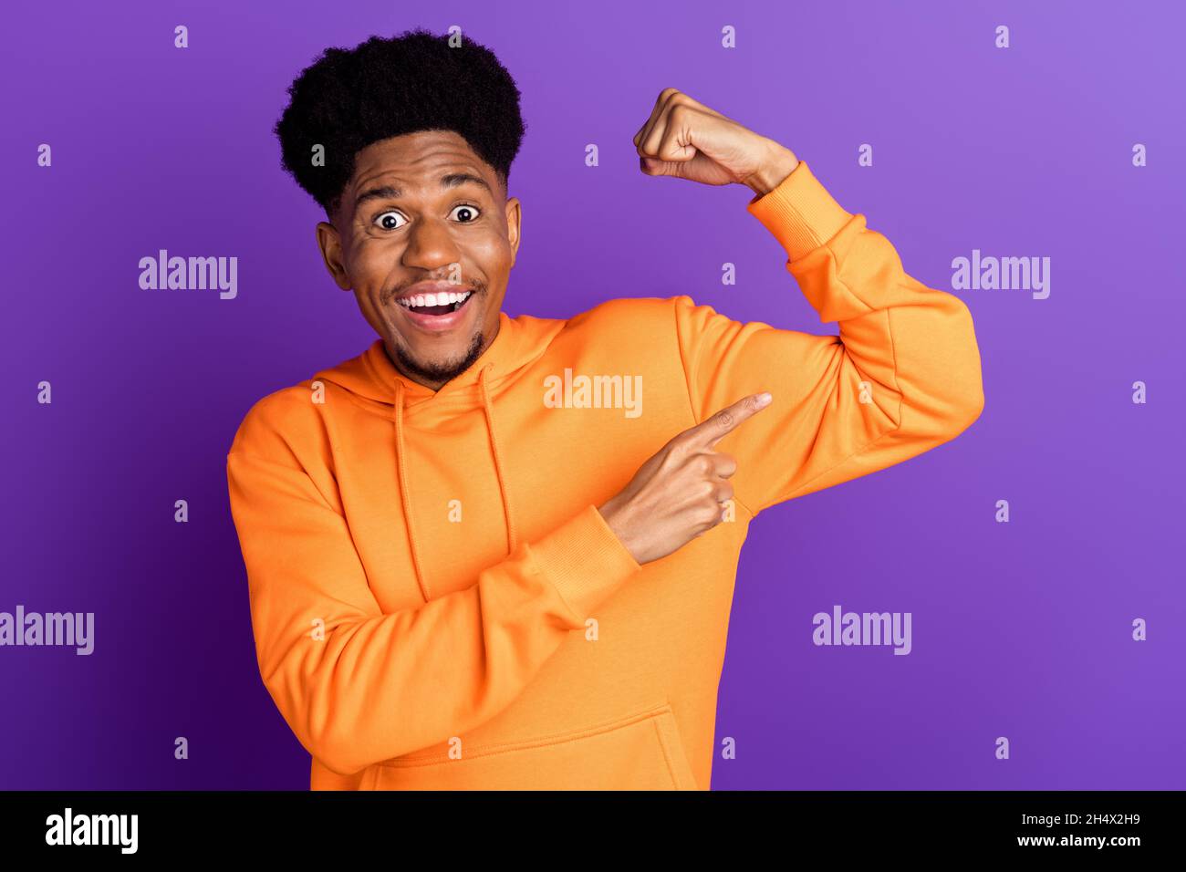 Young man point at biceps hi-res stock photography and images - Alamy