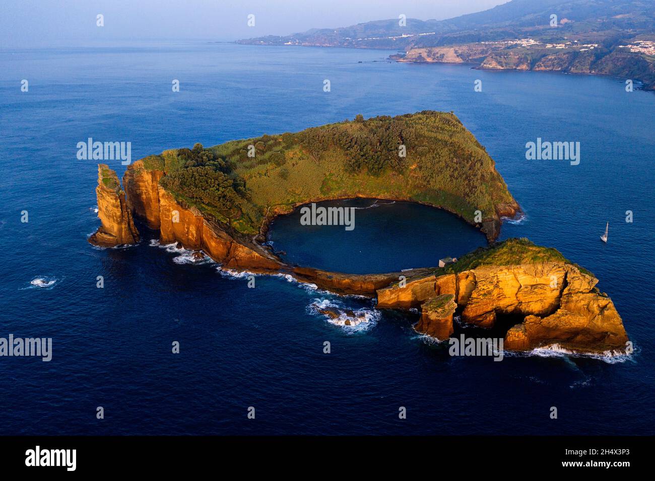Aerial view of volcanic island of Vila Franca do Campo and sailboat ...