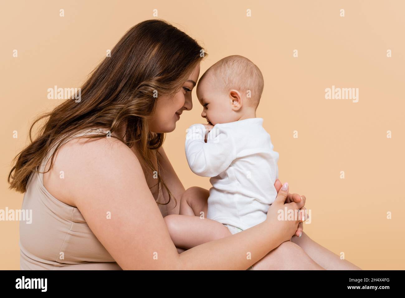 Side view of woman with overweight holding baby daughter isolated on ...