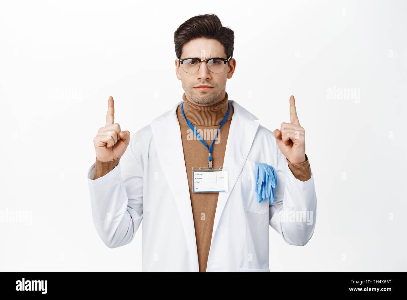 Angry doctor frowning, pointing up with displeased moody face ...