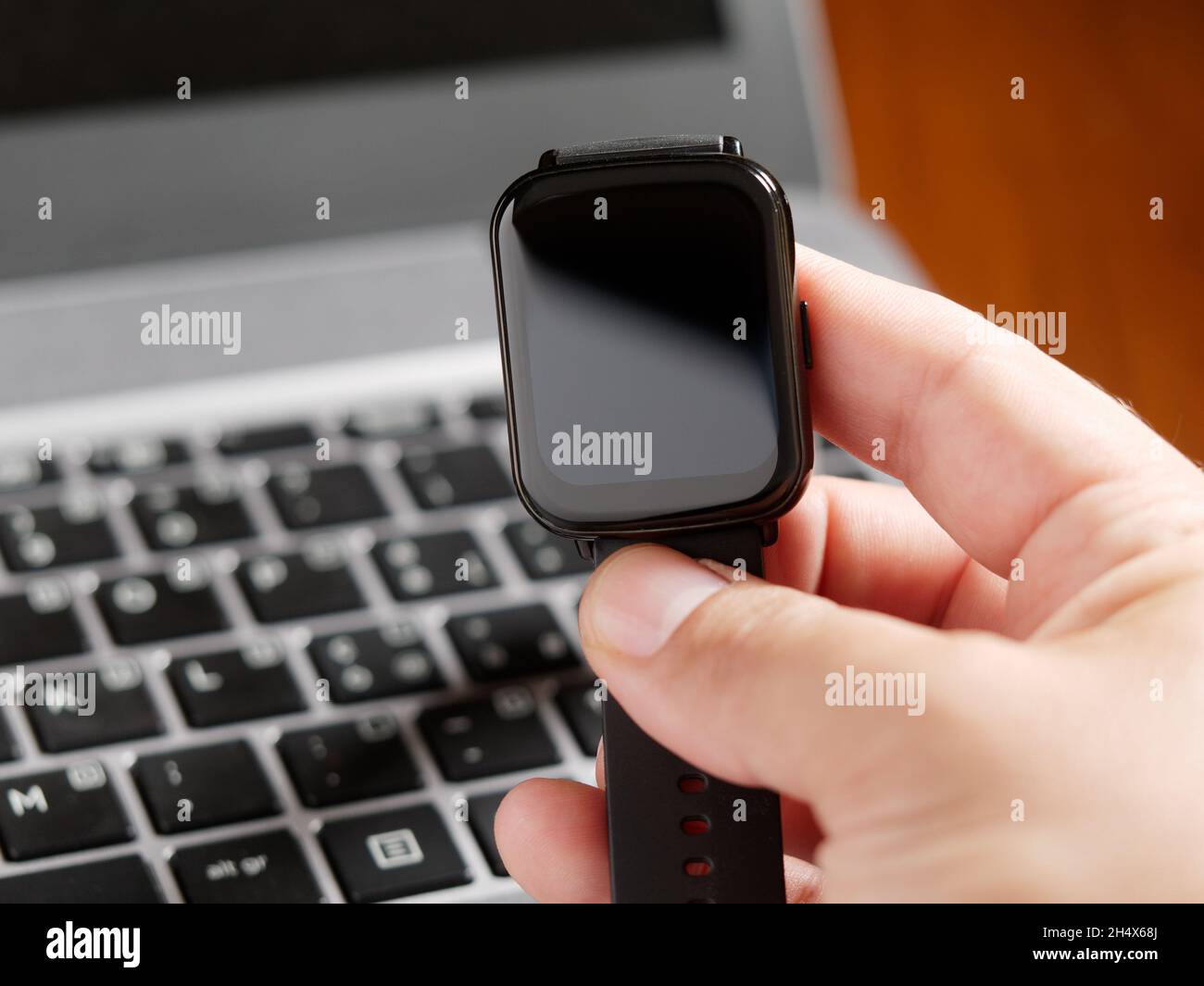 Male hand checking smartwatch keyboard of his laptop computer. Man ...