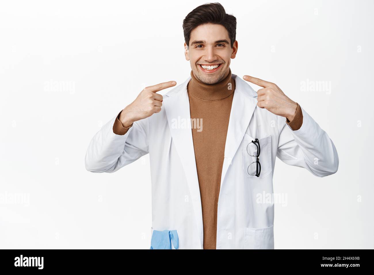 Image of handsome doctor, dentist pointing fingers at white smile ...