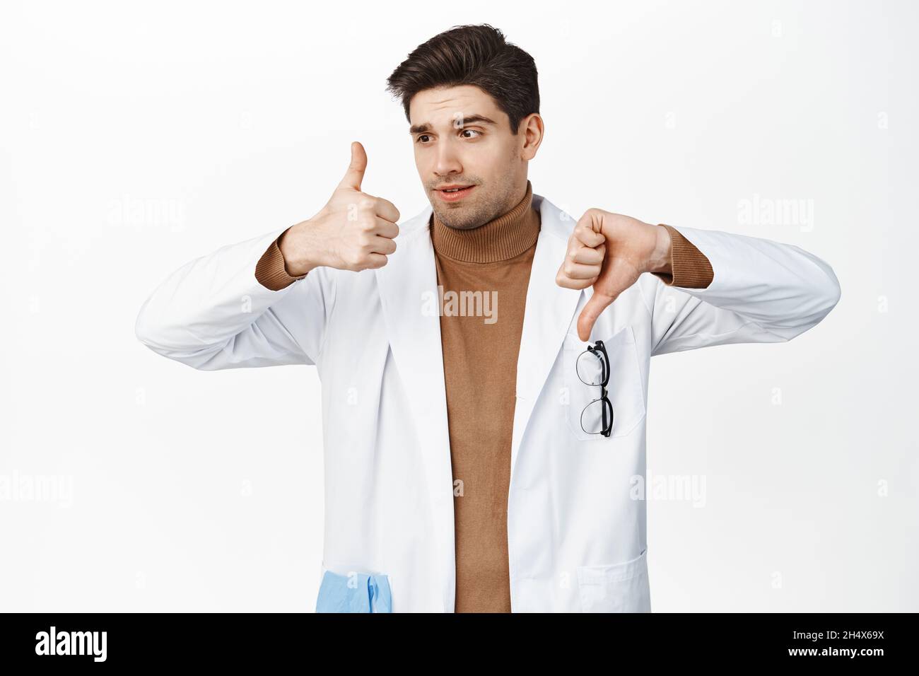 Indecisive healthcare worker showing thumb up and thumb down, pros or ...