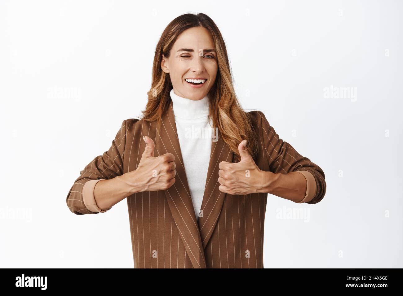 Smiling satisfied businesswoman showing thumbs up and nod in approval ...
