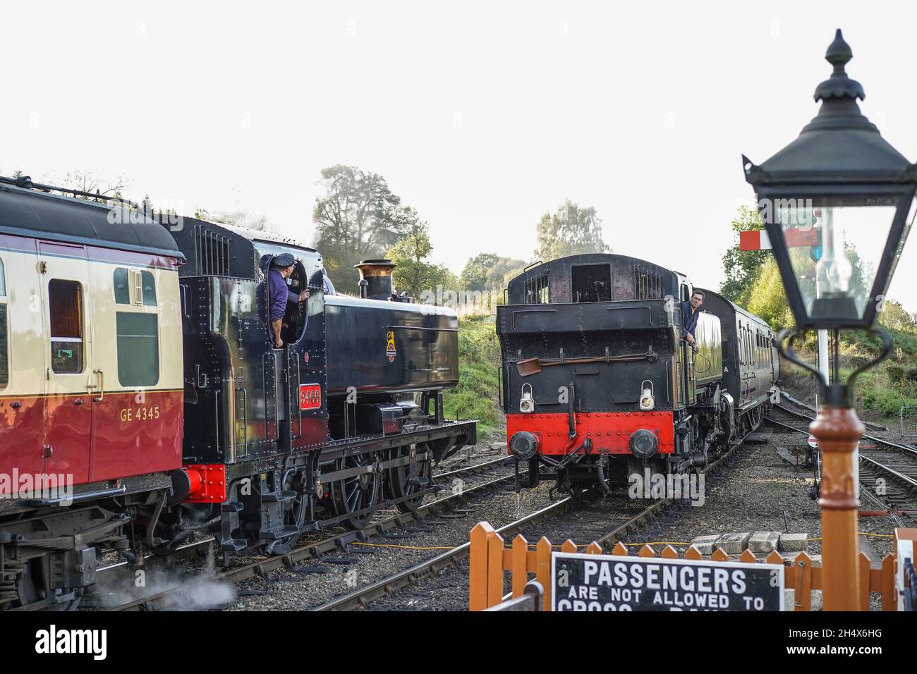 Two steam trains passing on the tracks at a UK heritage railway station ...