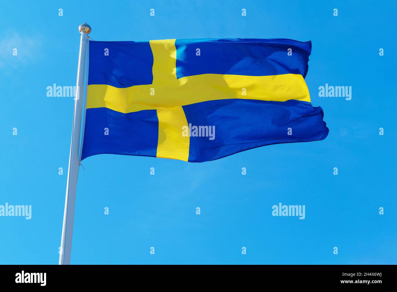 Flag of Sweden or swedish flag waving on a blue clear sky background ...