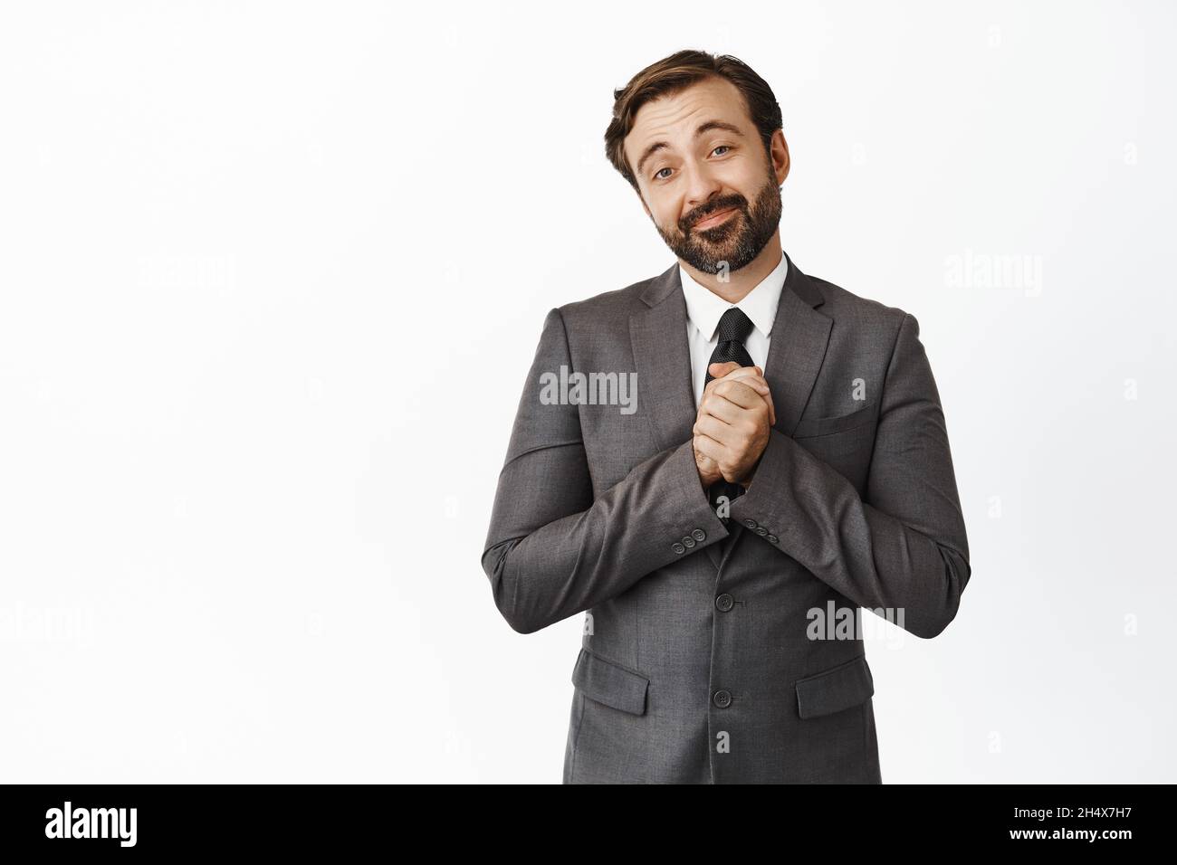 Portrait of pleased and touched businessman, holding hands clenched ...