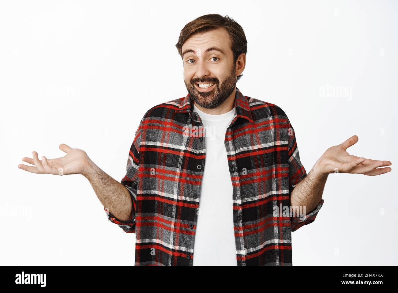 Oops sorry. Cute smiling adult man shrugging shoulders, looking guily ...