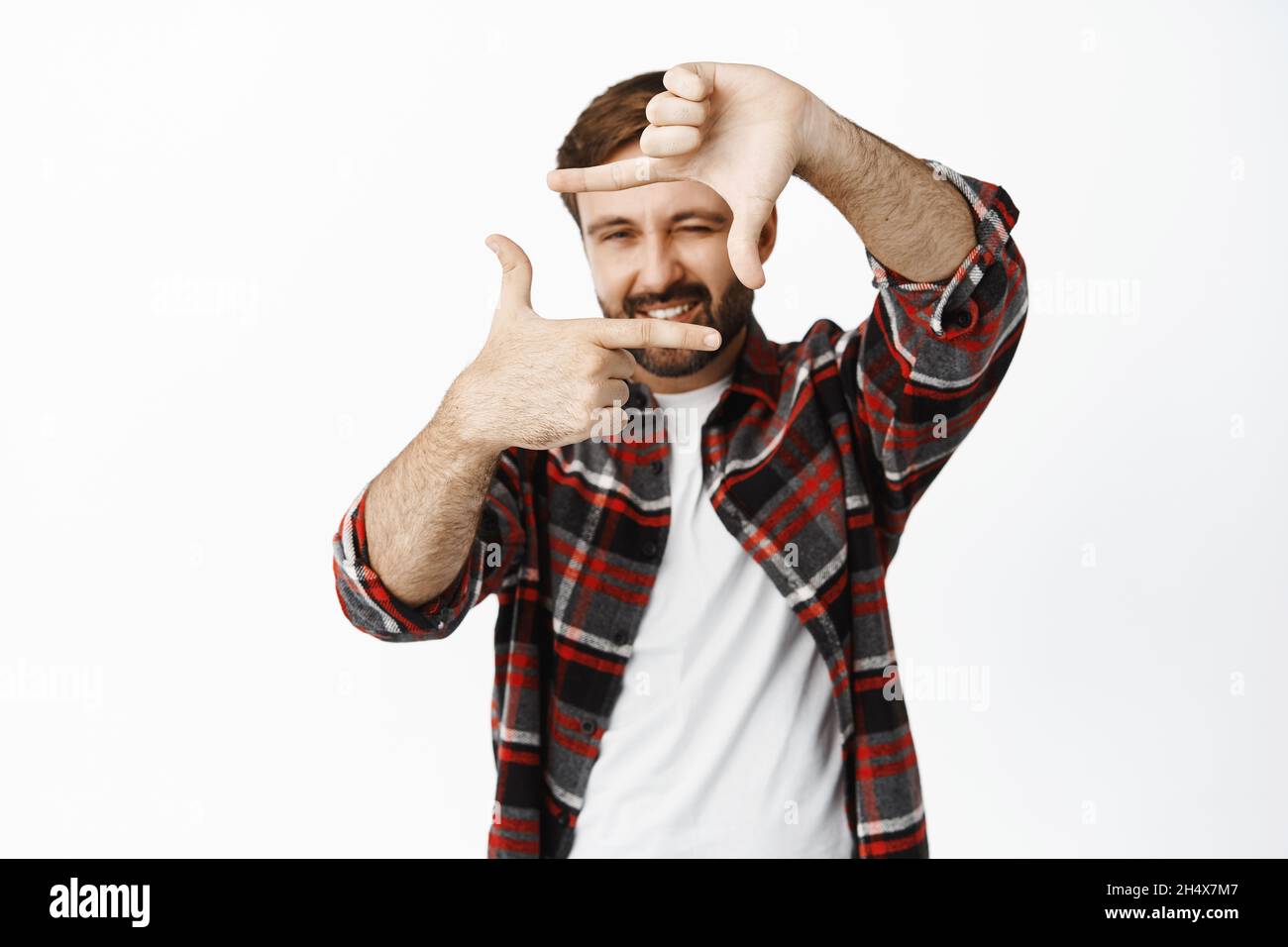 Portrait of creative man looking through hand frames and searching ...