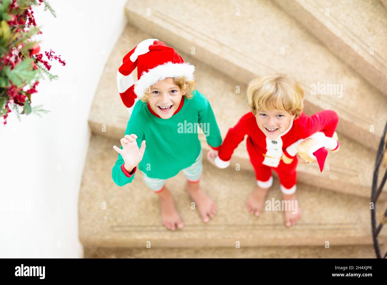 Kids running stairs on Christmas morning. Children in pajamas run ...