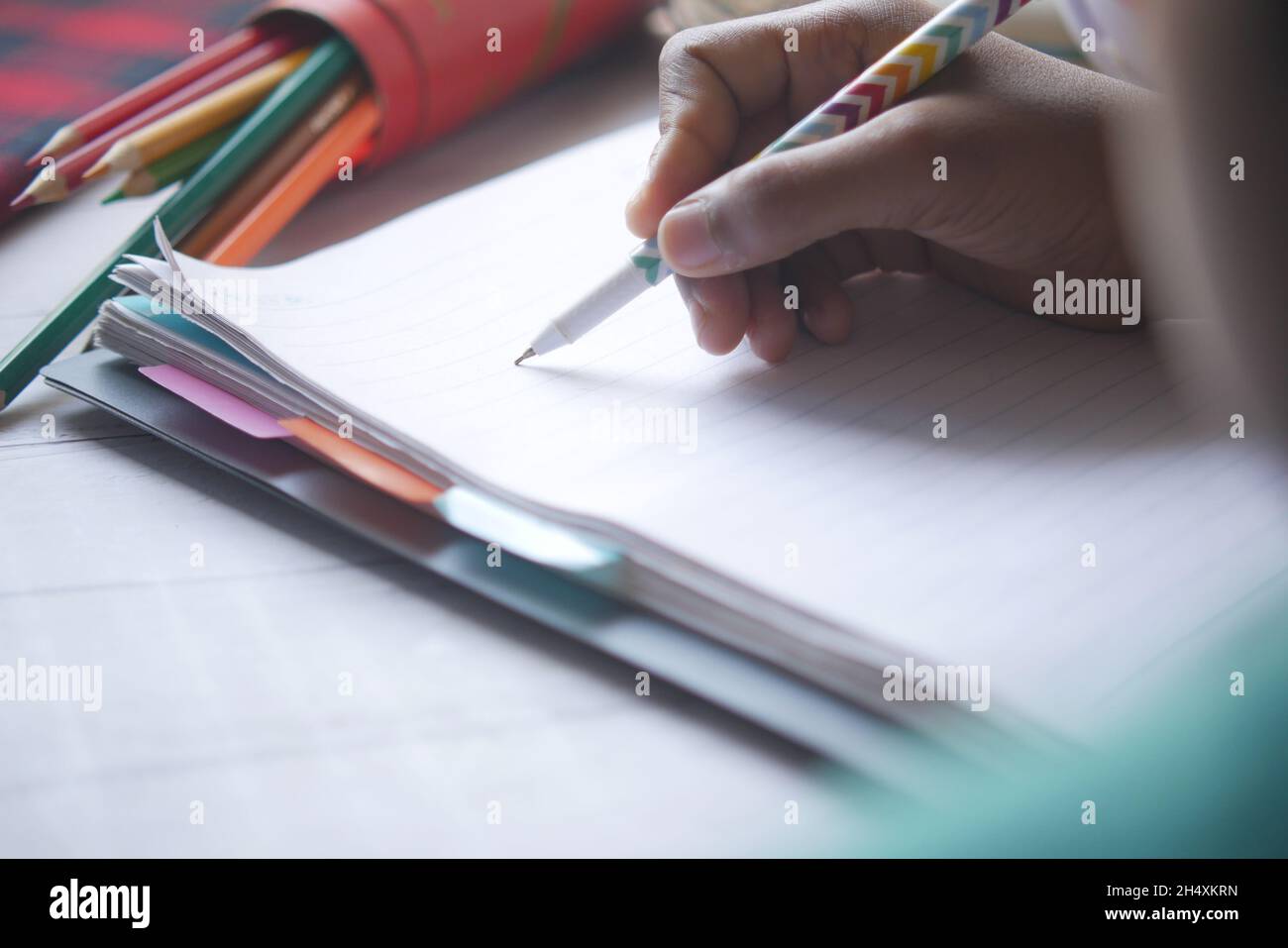 rear view of child boy hand writing on notepad Stock Photo - Alamy