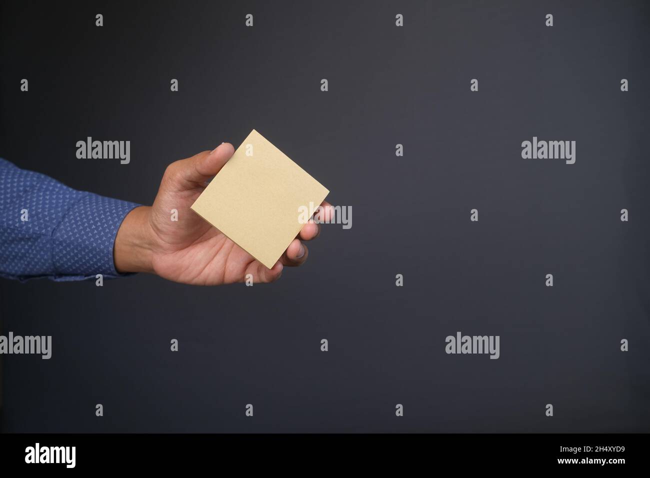 man hand hold a sticky note against gray background Stock Photo - Alamy