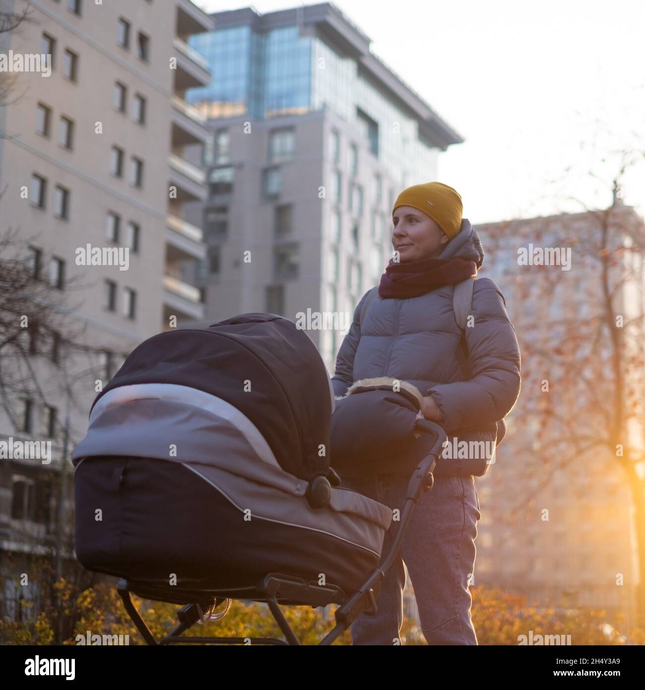 Happy young mother with pram during the walk Stock Photo - Alamy