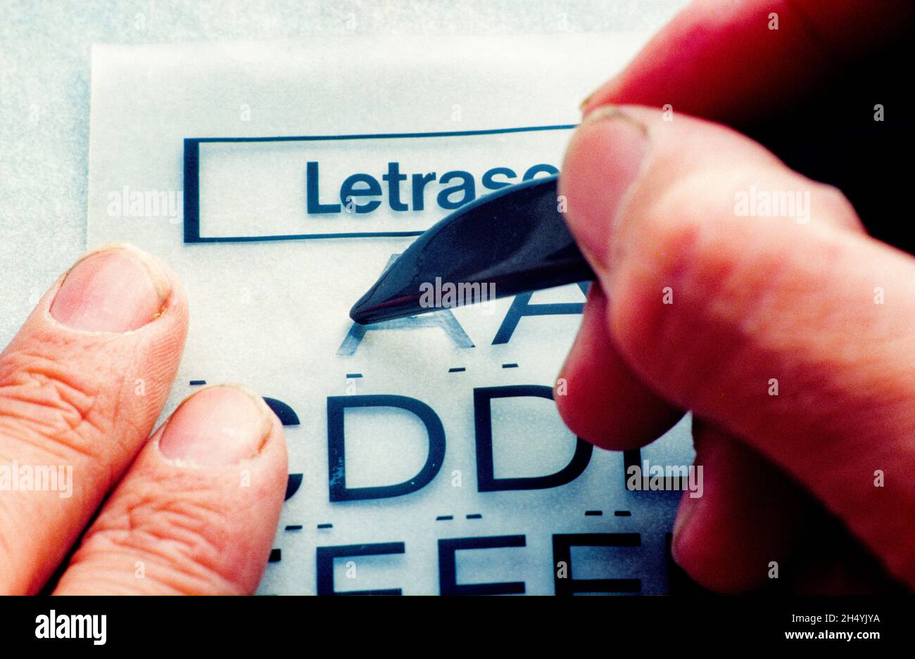 Graphic designer using Letraset, dry transfer lettering system in the ...