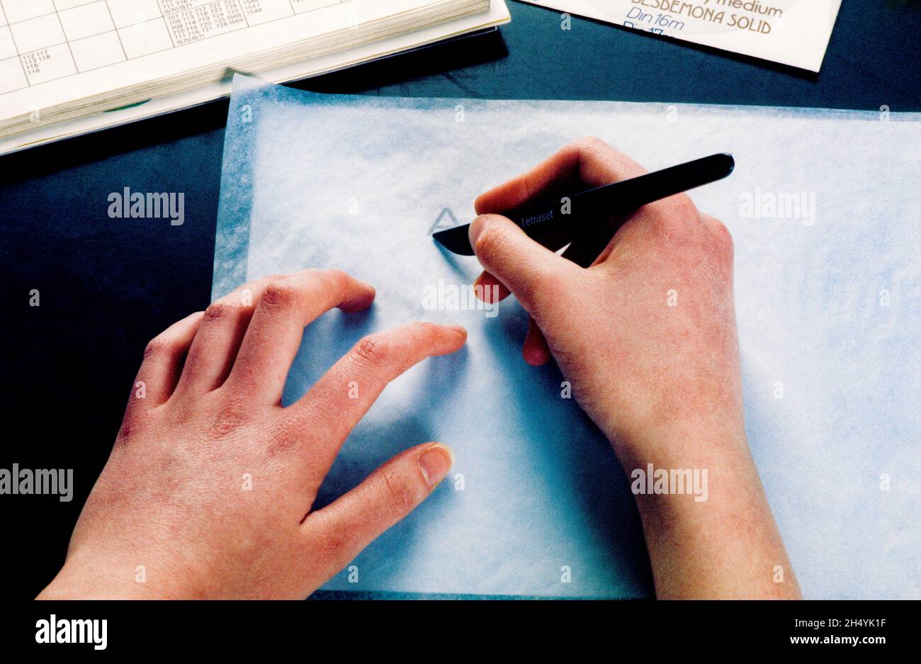 Graphic designer using Letraset, dry transfer lettering system in the ...