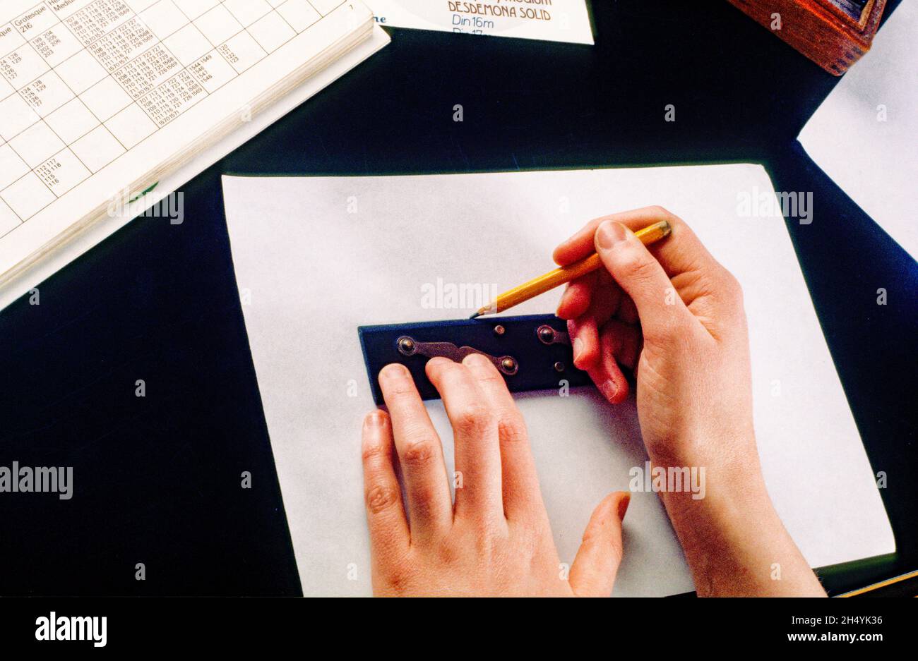 Graphic designer using Letraset, dry transfer lettering system in the ...