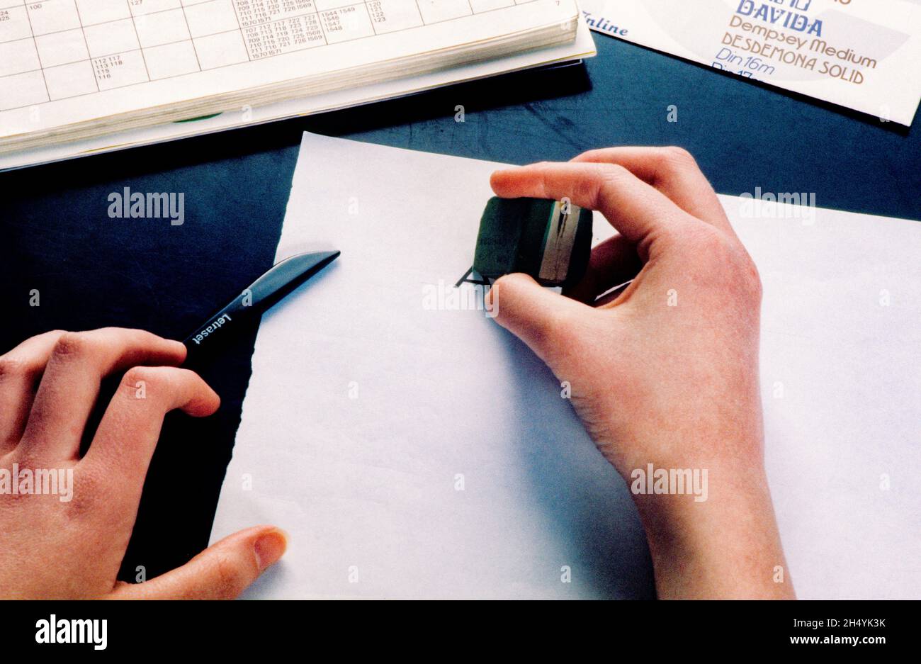 Graphic designer using Letraset, dry transfer lettering system in the ...