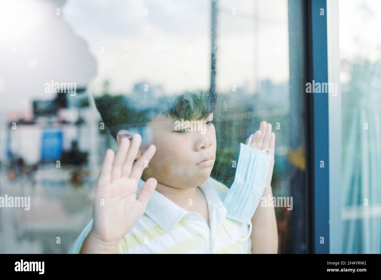 Boy looking out window sad hi-res stock photography and images - Alamy