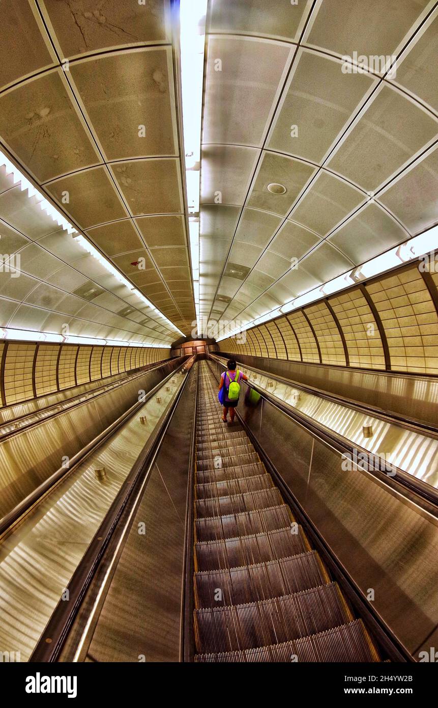 Vertical shot of a person on an escalator in a station, Manhattan ...