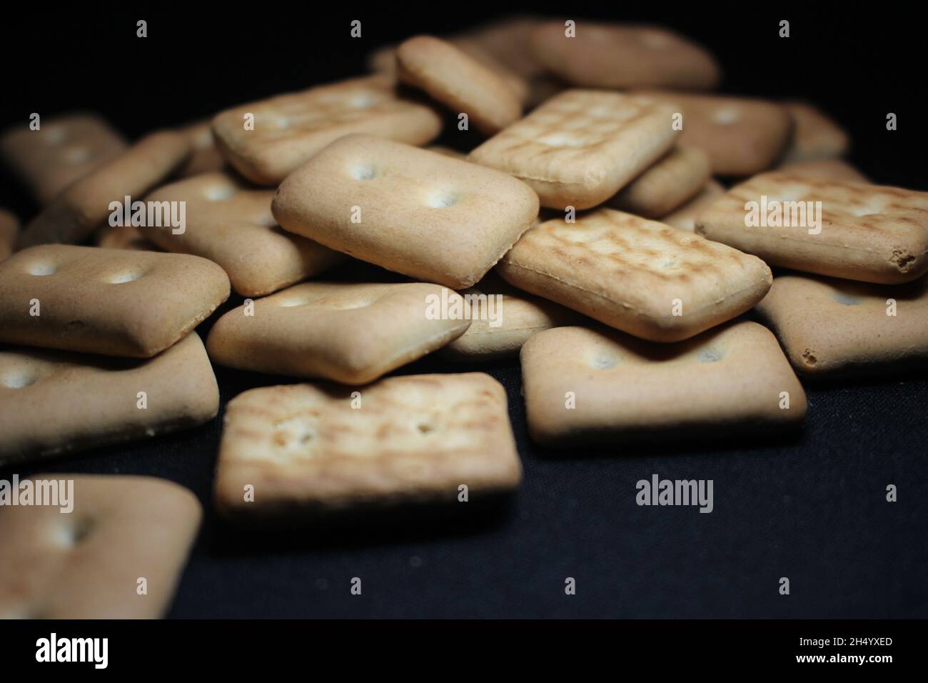 Selective shot of rectangular biscuits with small pores on the black ...