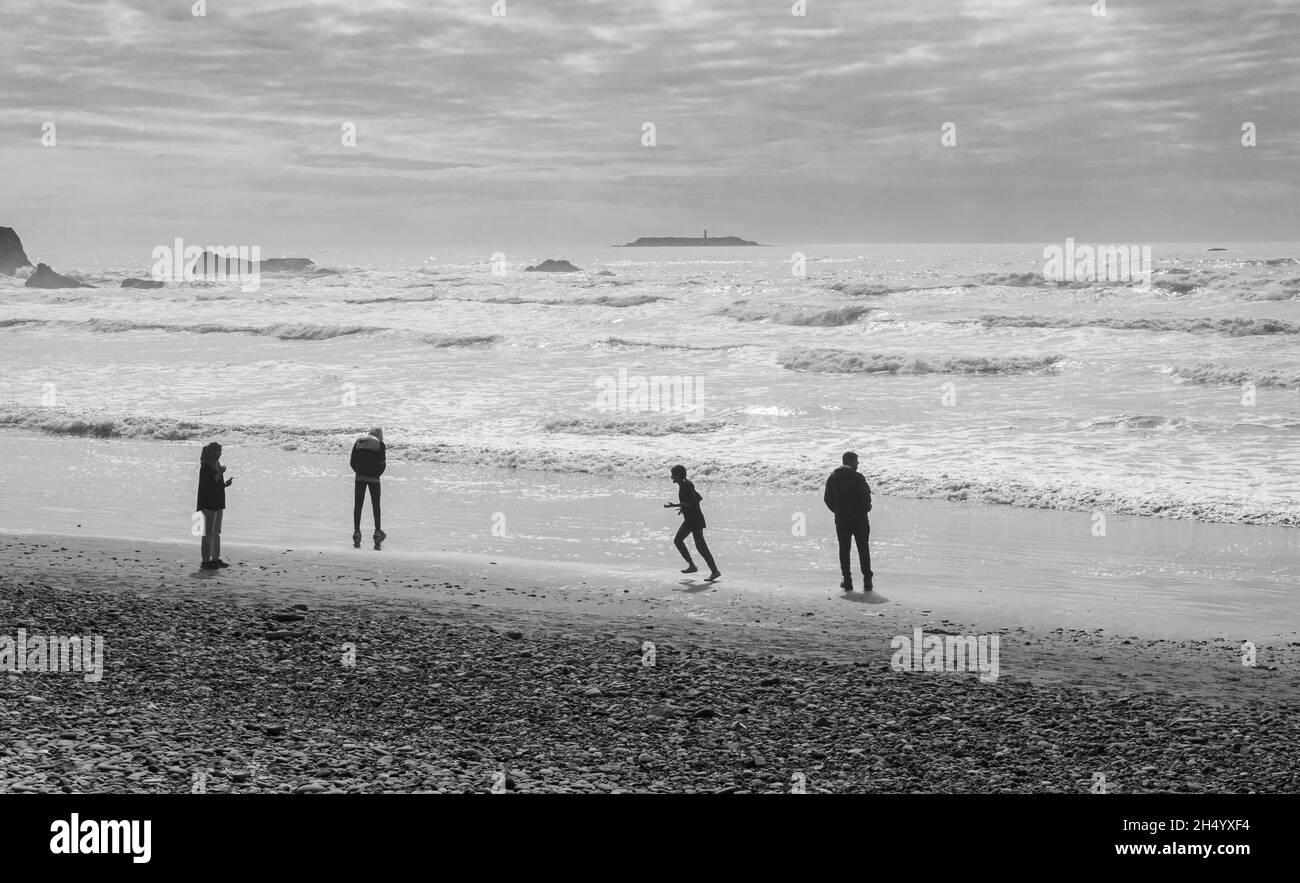 A family walks to the water's edge to enjoy the waves at Ruby Beach ...