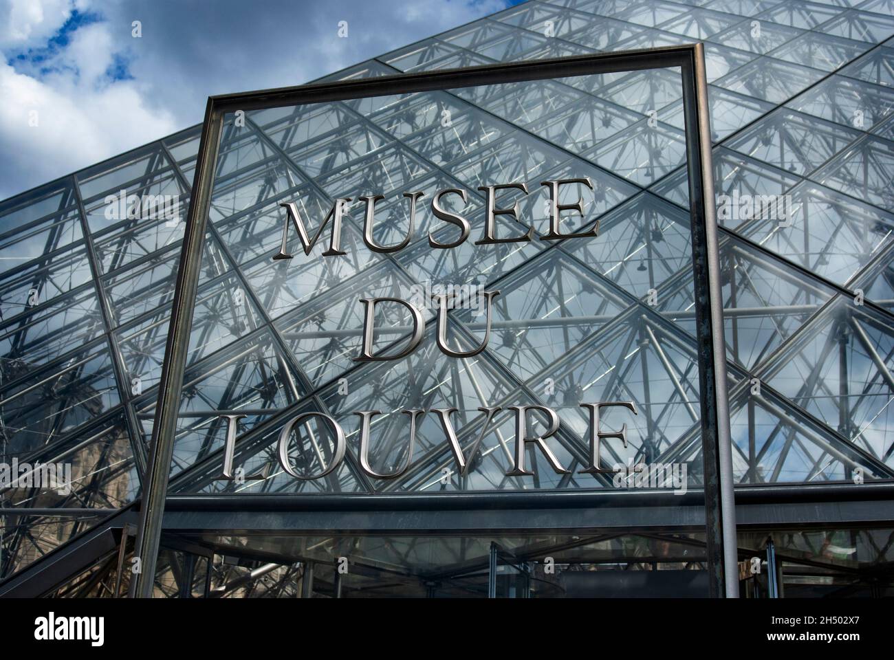 The Louvre Museum sign before entrance in the Glass Pyramid, Paris ...