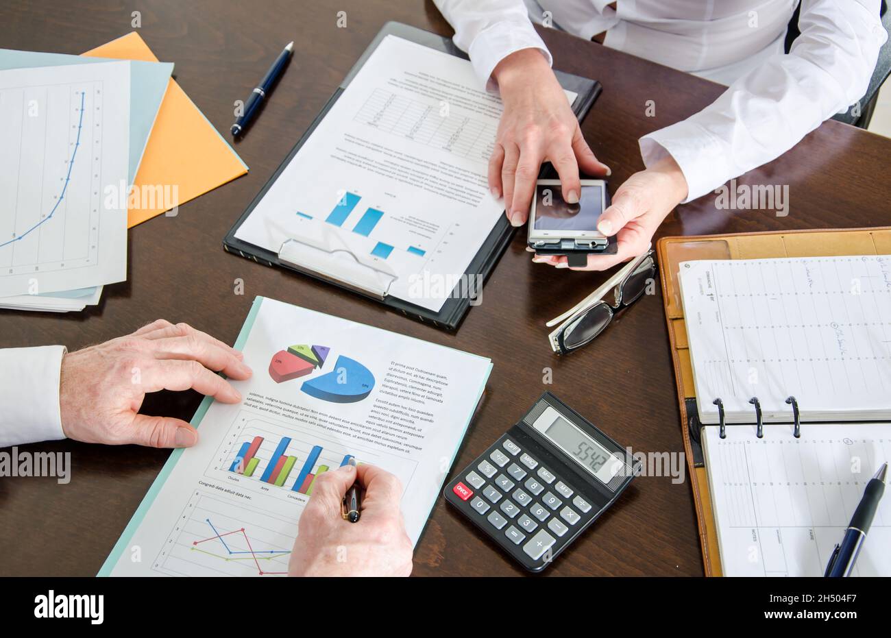 Two business people analyzing charts Stock Photo - Alamy