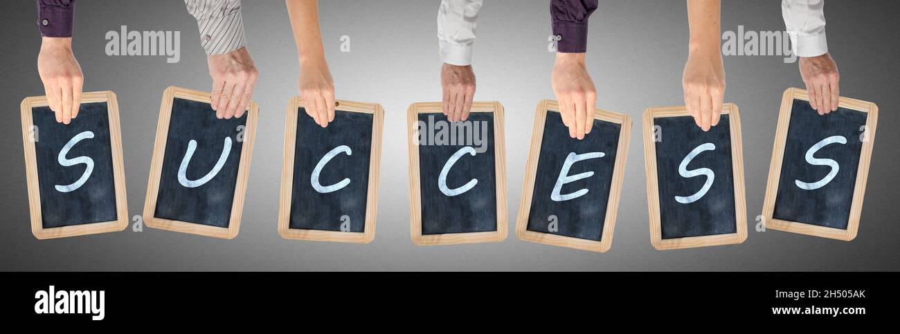 Letters of the word success written on chalkboards held by hands Stock ...