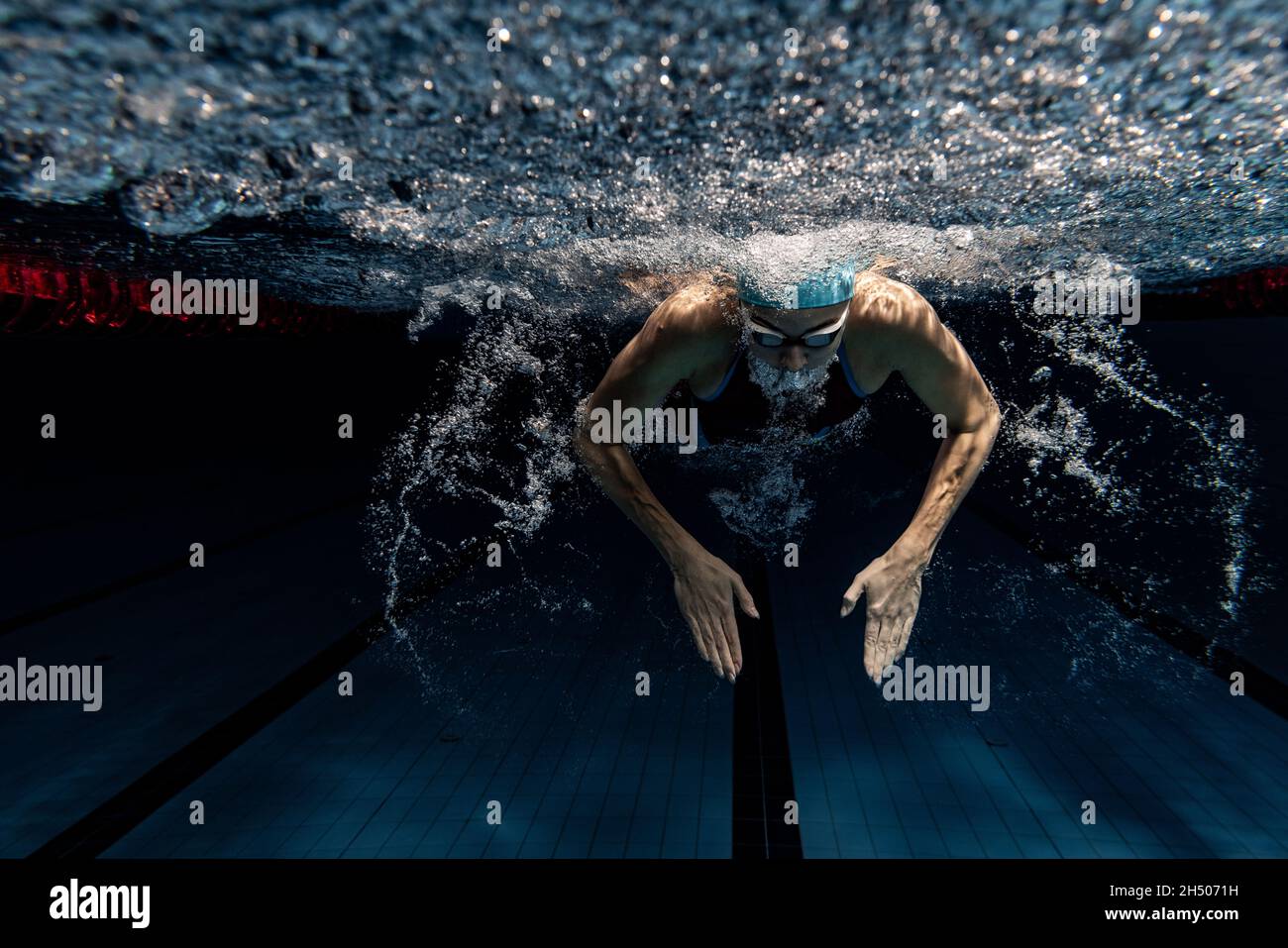 Underwater view of swimming movements details. One female swimmer in ...