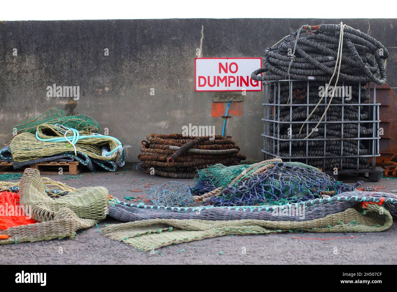 Fishing men prepare their nets and boats before heading out to sea from ...