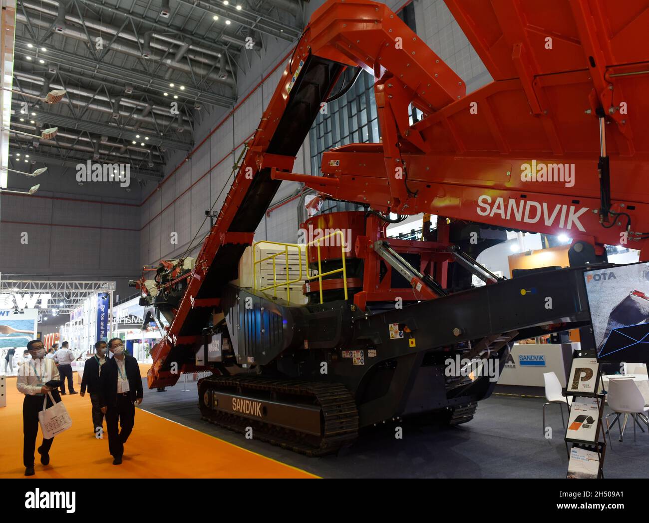 Shanghai, China. 5th Nov, 2021. Visitors walk past a Sandvik vehicle on ...