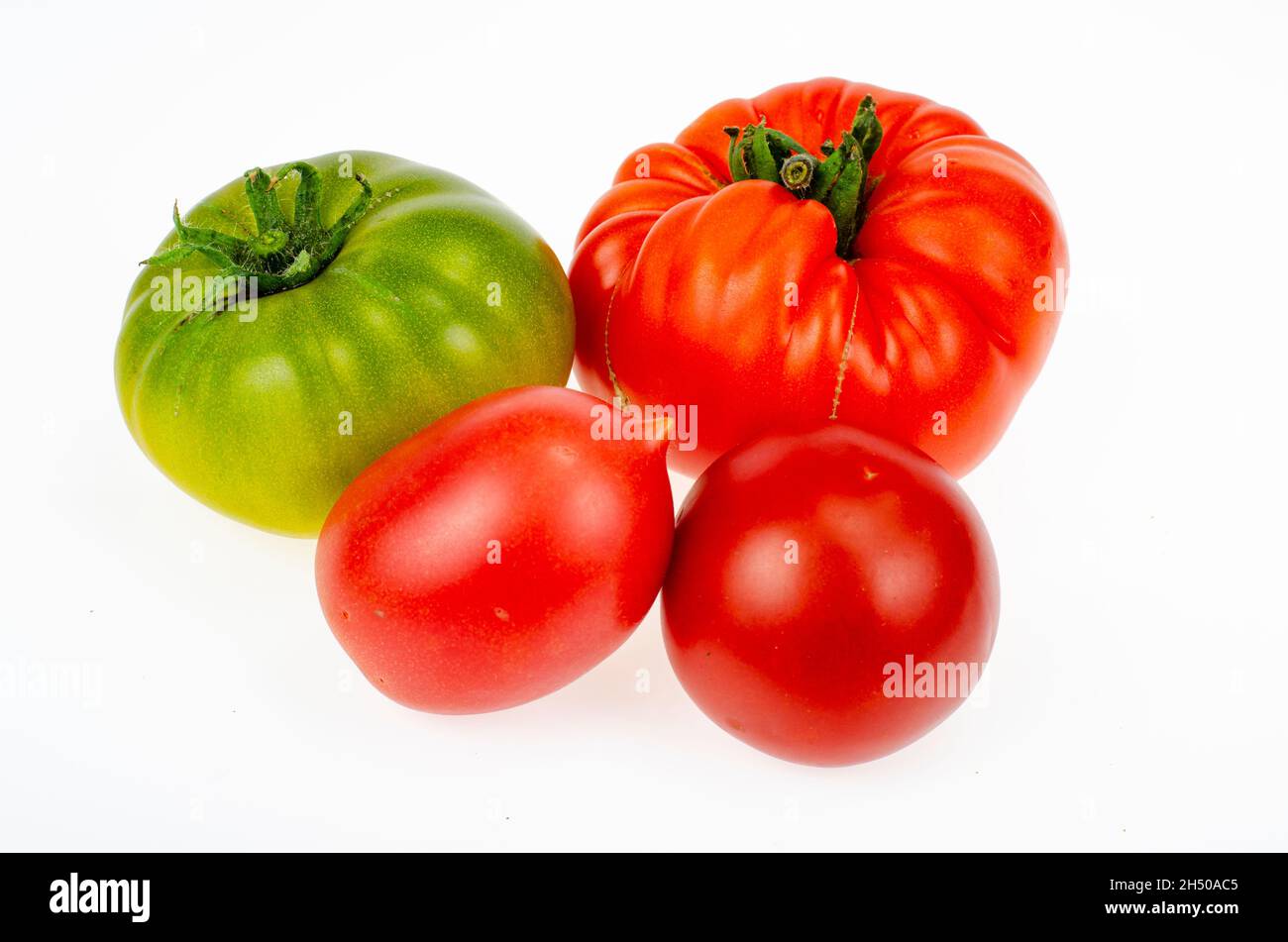 Colored tomatoes of different varieties on white background. Studio ...