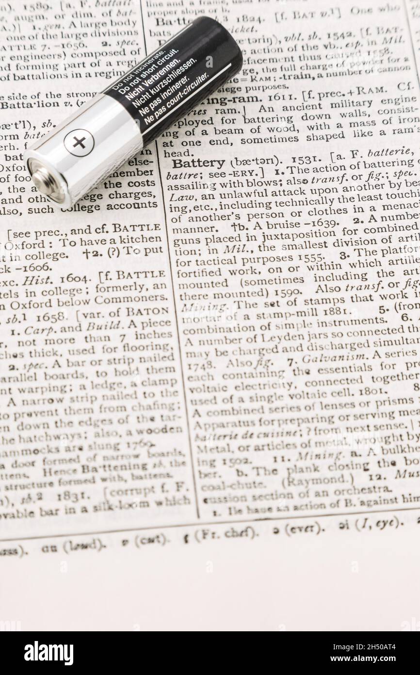 Vertical closeup of the silver and black battery on a dictionary page ...
