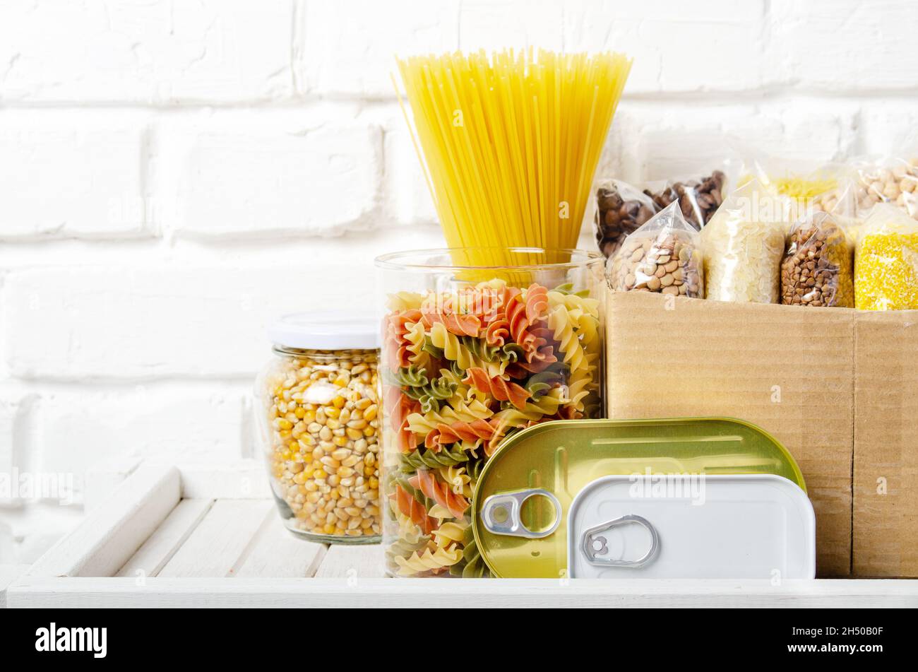 Set of uncooked foods on pantry shelf prepared for disaster emergency ...