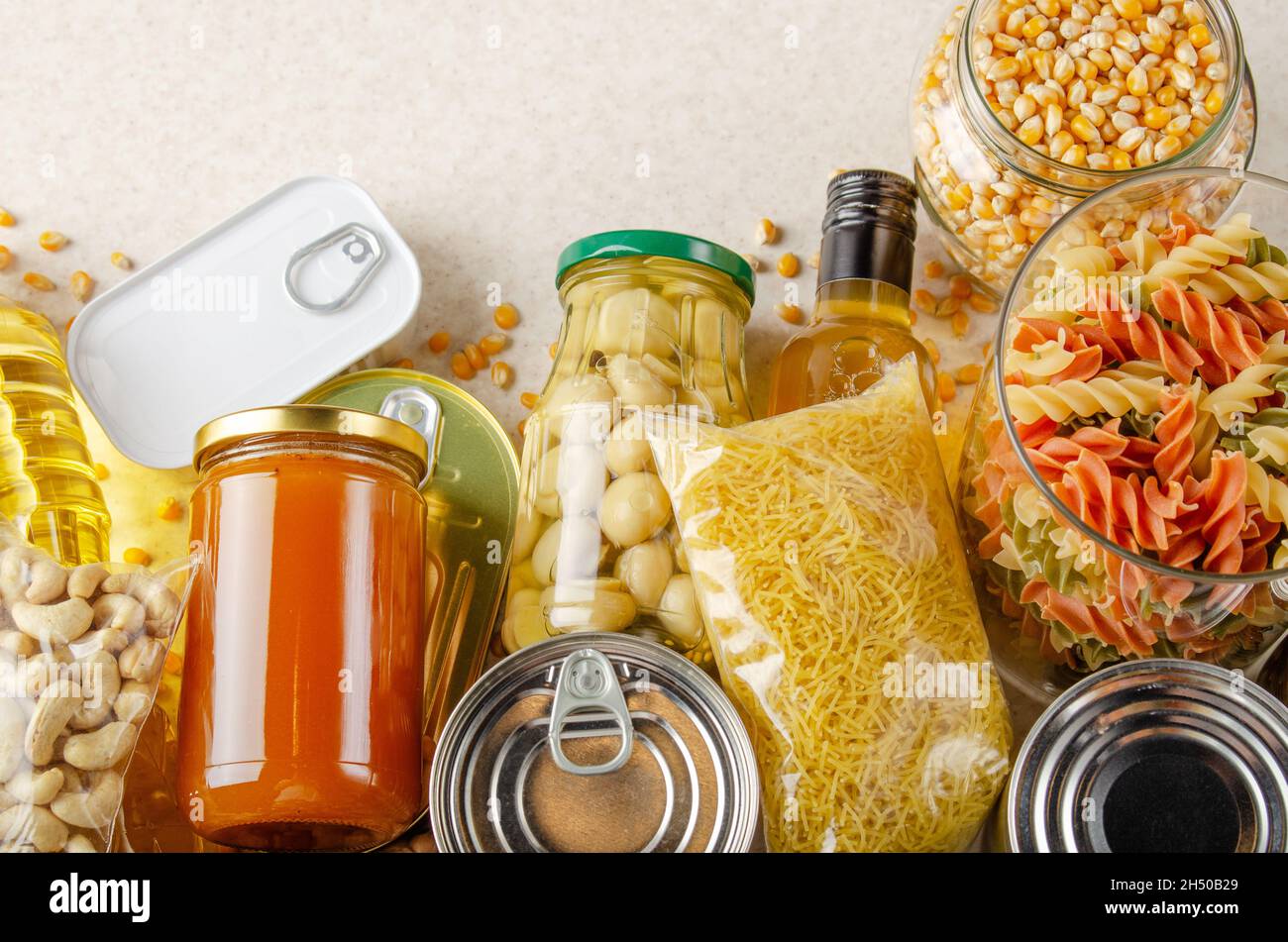 Flat lay view at kitchen table full with non-perishable foods. Spase ...