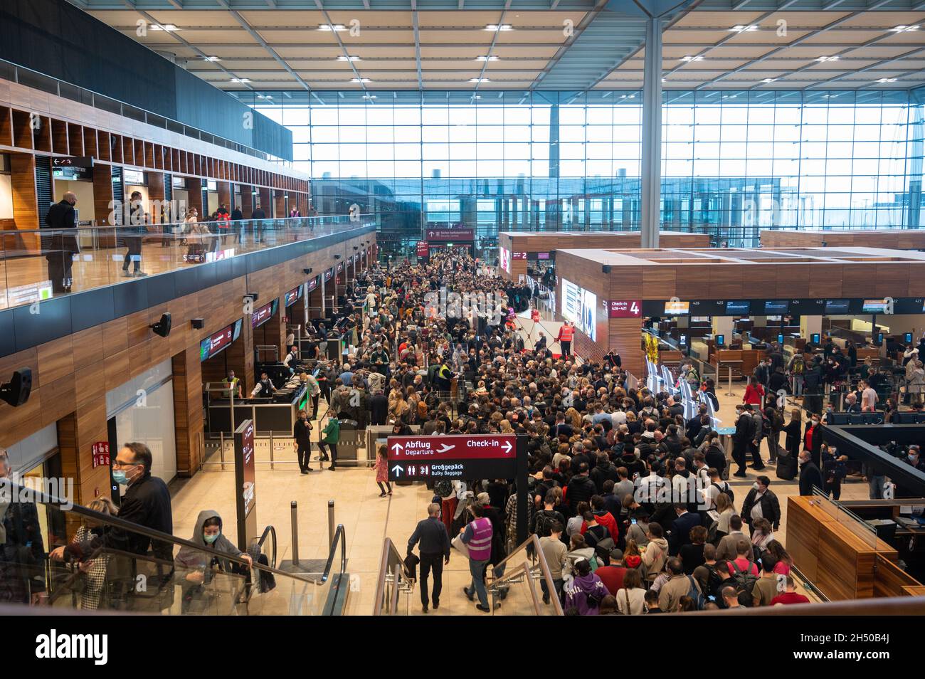 05 November 2021, Brandenburg, Schönefeld: Passengers queue in front of ...