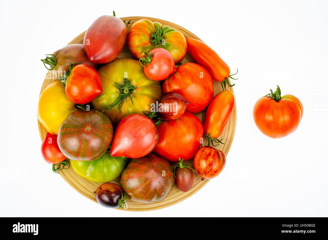Colored tomatoes of different varieties on white background. Studio ...