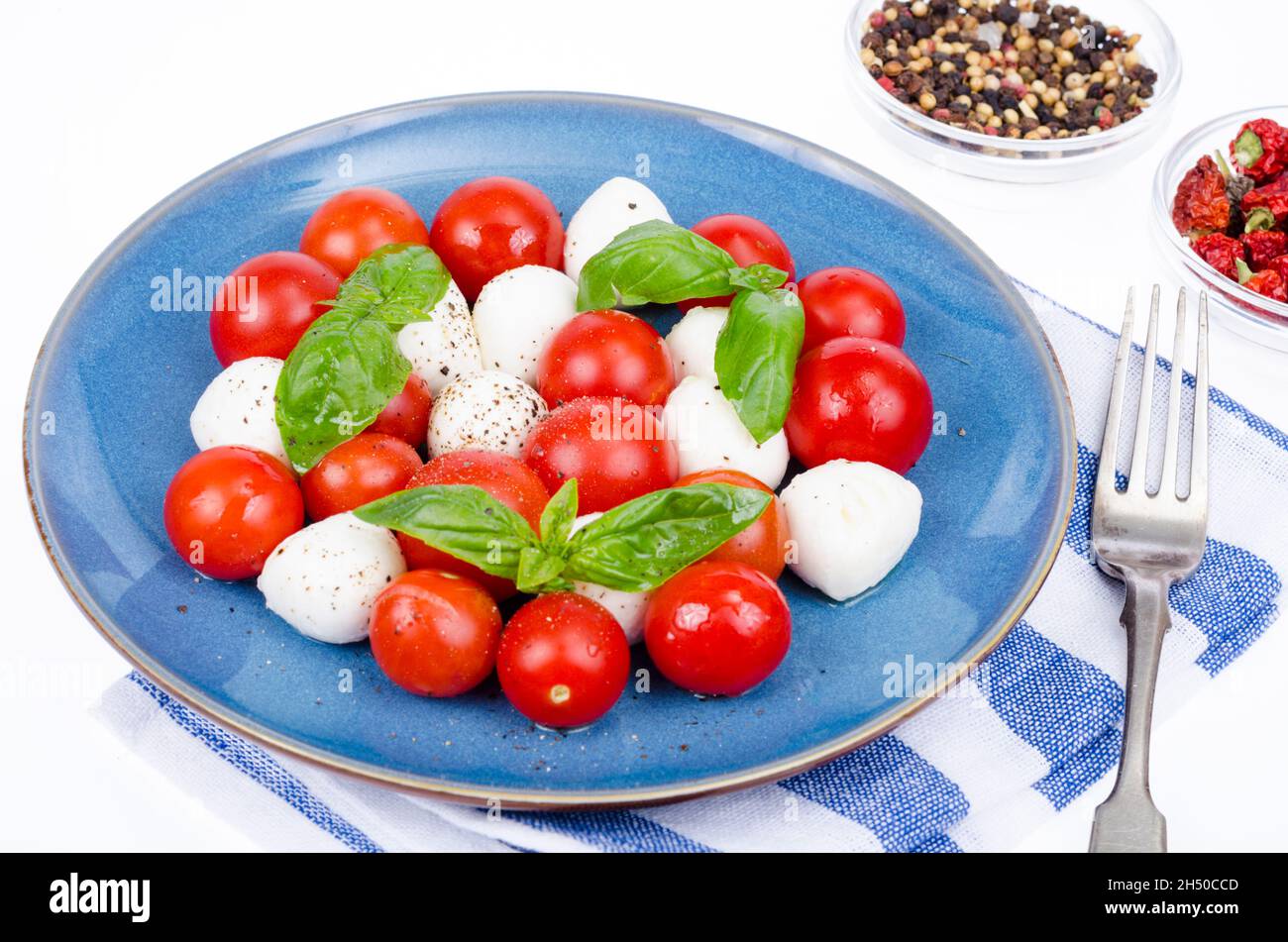 Vegetable salad with mozzarella balls on plate, white background ...