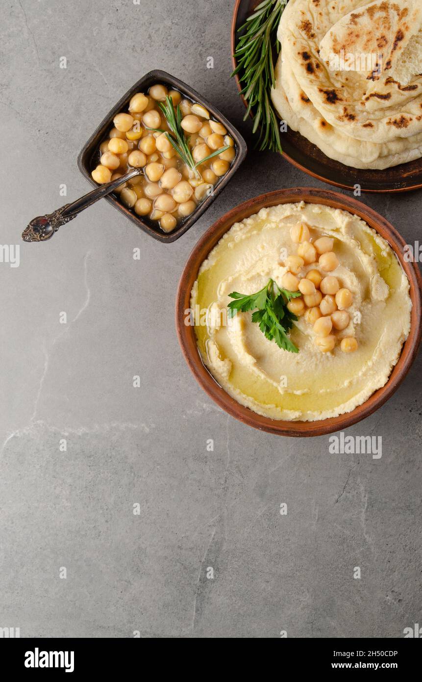 Flat lay Hummus in clay dish topped with chickpeas and green coriander ...