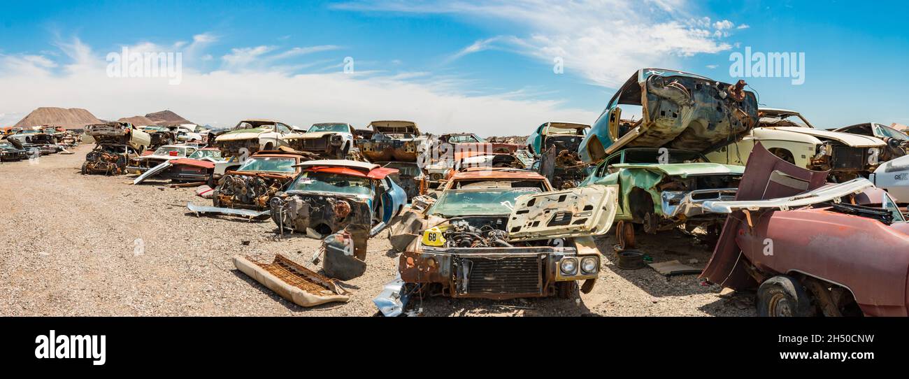 Panoramic view of a large junkyard featuring numerous rusted and ...