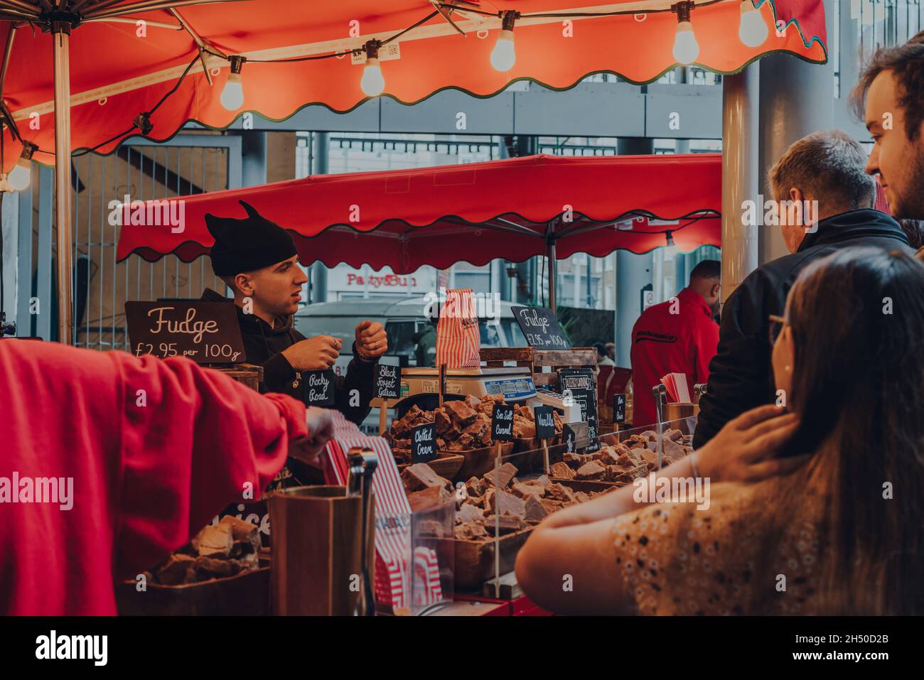 London, UK - October 17, 2021: Seller and customers at a fudge stall ...